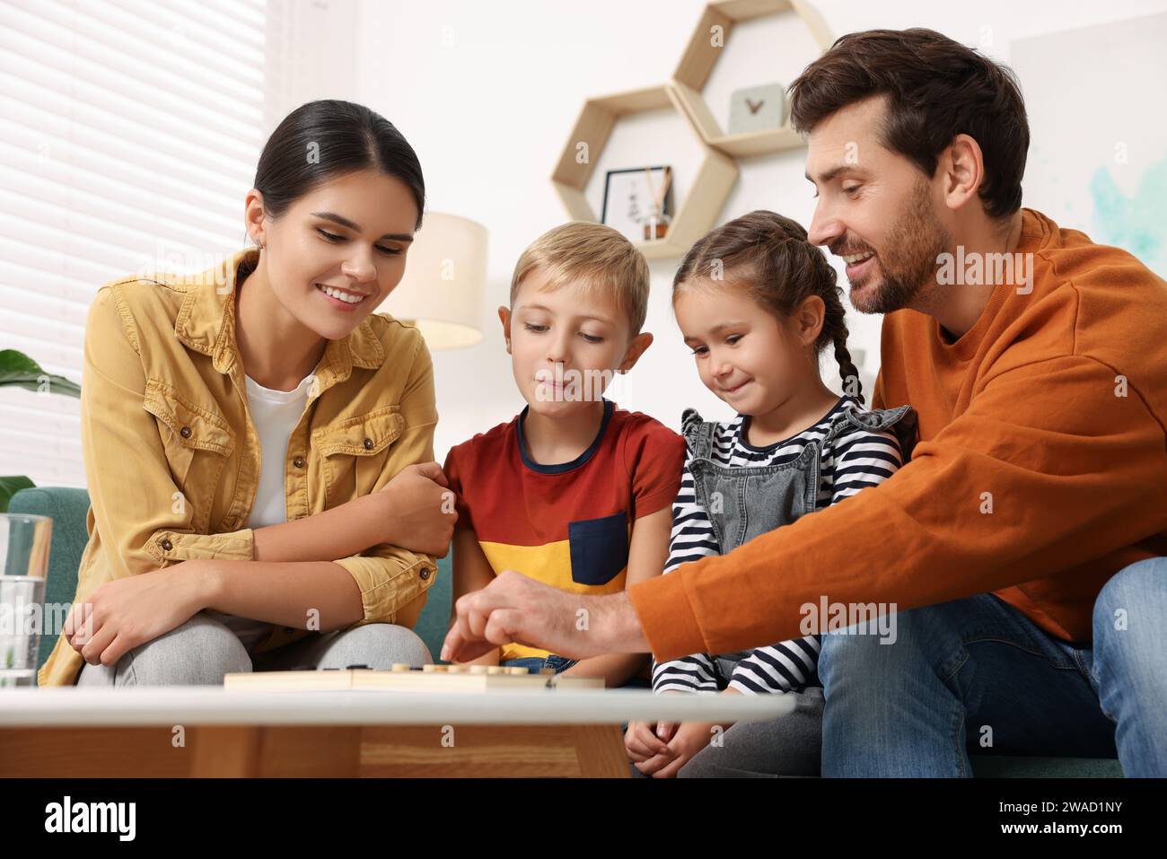 Family playing checkers at coffee table in room Stock Photo - Alamy