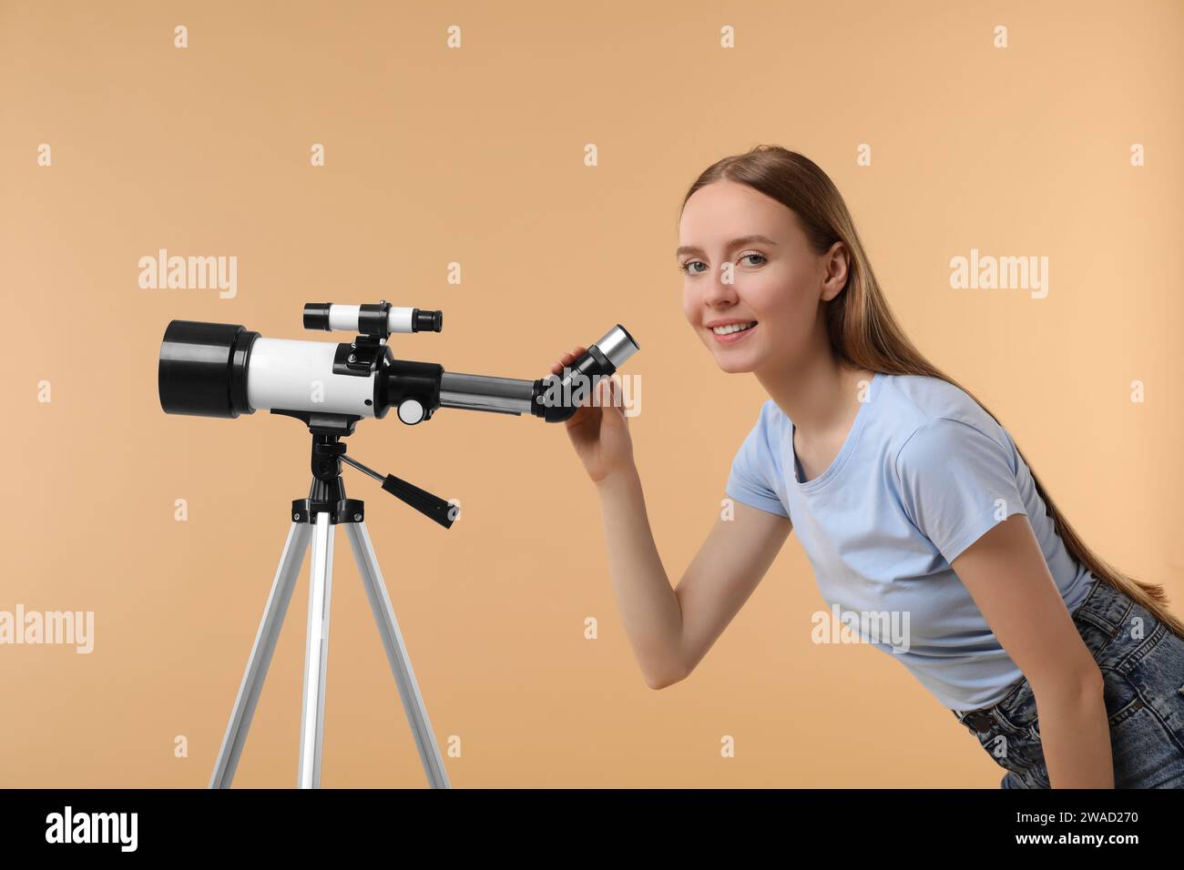 Happy astronomer with telescope on beige background Stock Photo - Alamy