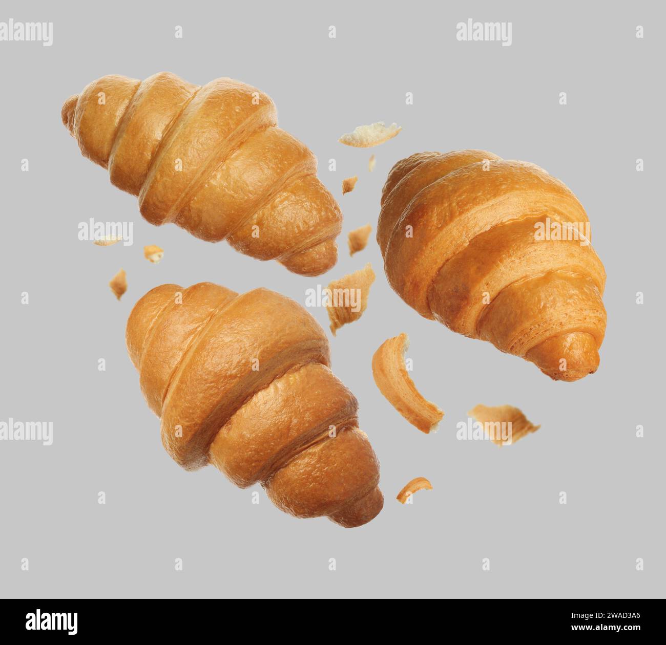 Delicious fresh croissants falling on grey background Stock Photo - Alamy