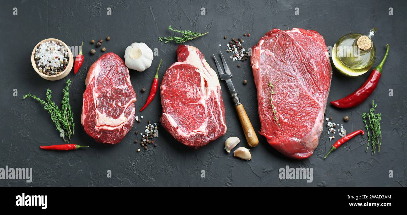 Raw beef meat, products and spices on dark textured table, flat lay ...