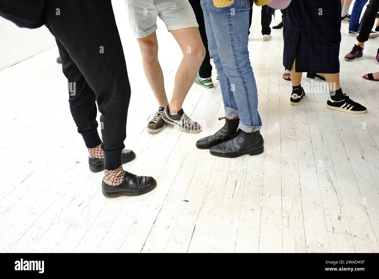 Body language of friends catching up at a Sydney art opening, legs and ...