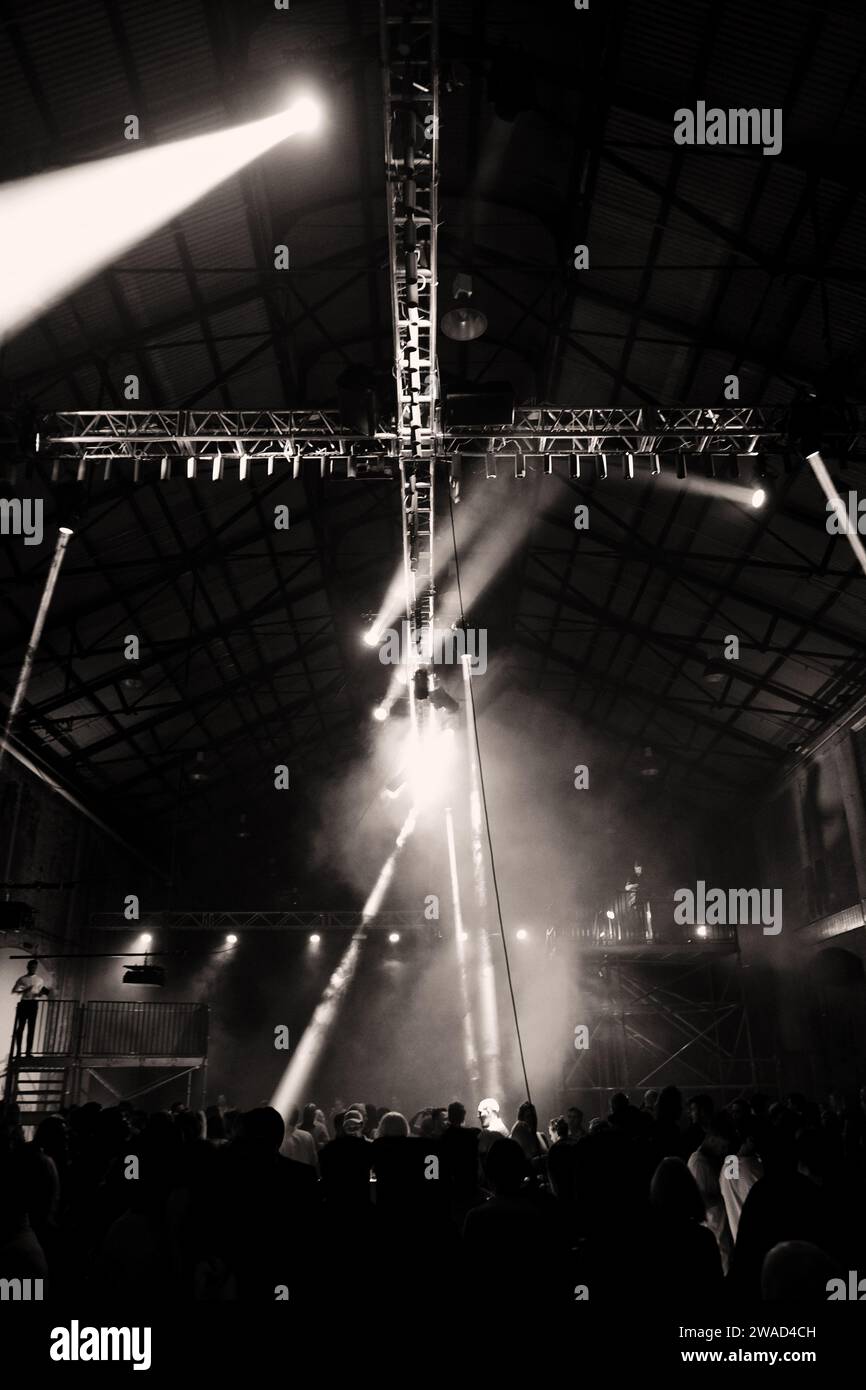 Spotlights, silhouettes a cross shaped sound rig for a music event in a ...