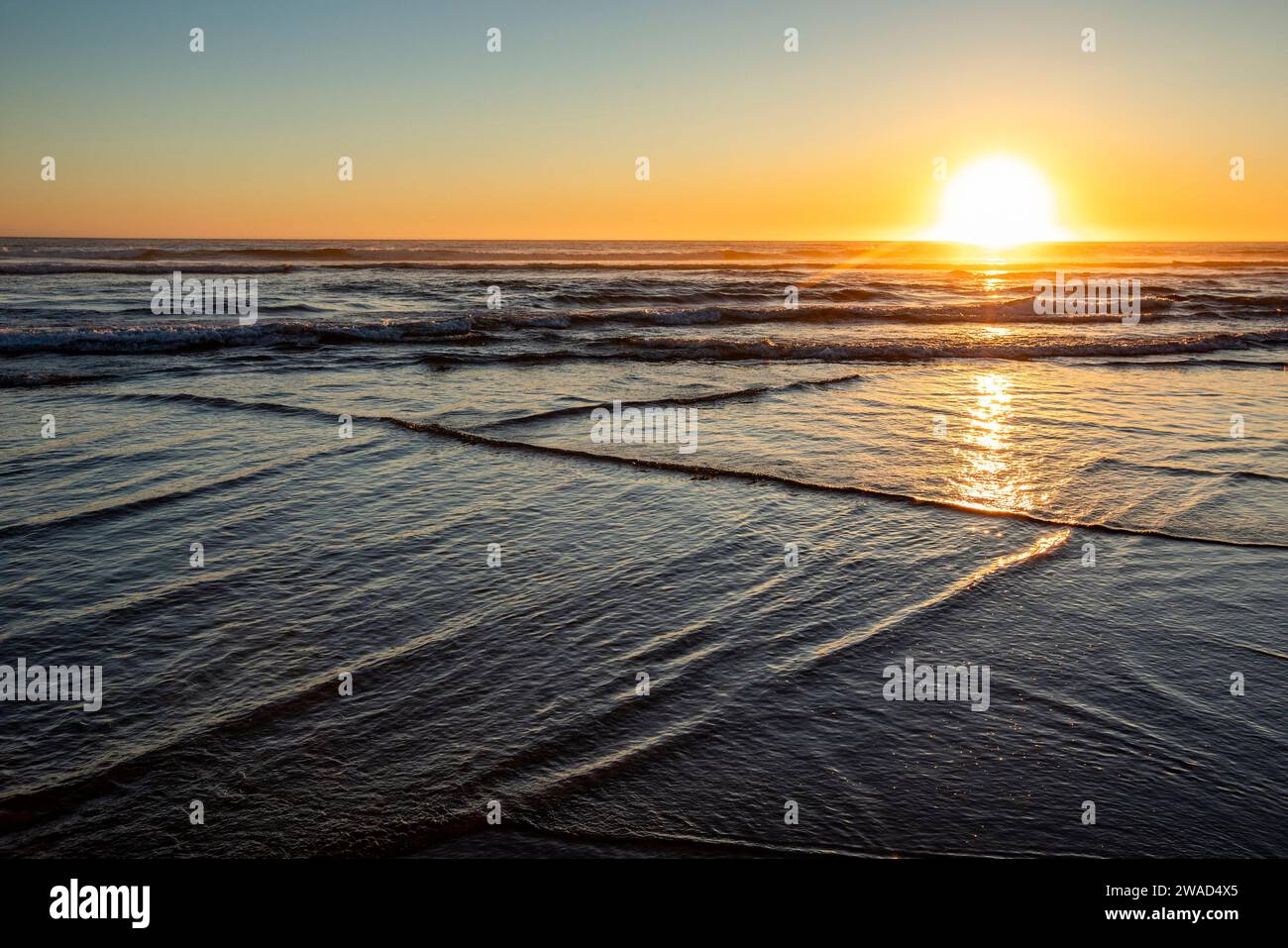 Sun setting over ocean at Cannon Beach Stock Photo - Alamy