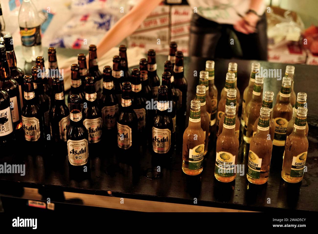 Detail of rows of bottles of Asahi Beer and Somerset Cider lined up at ...
