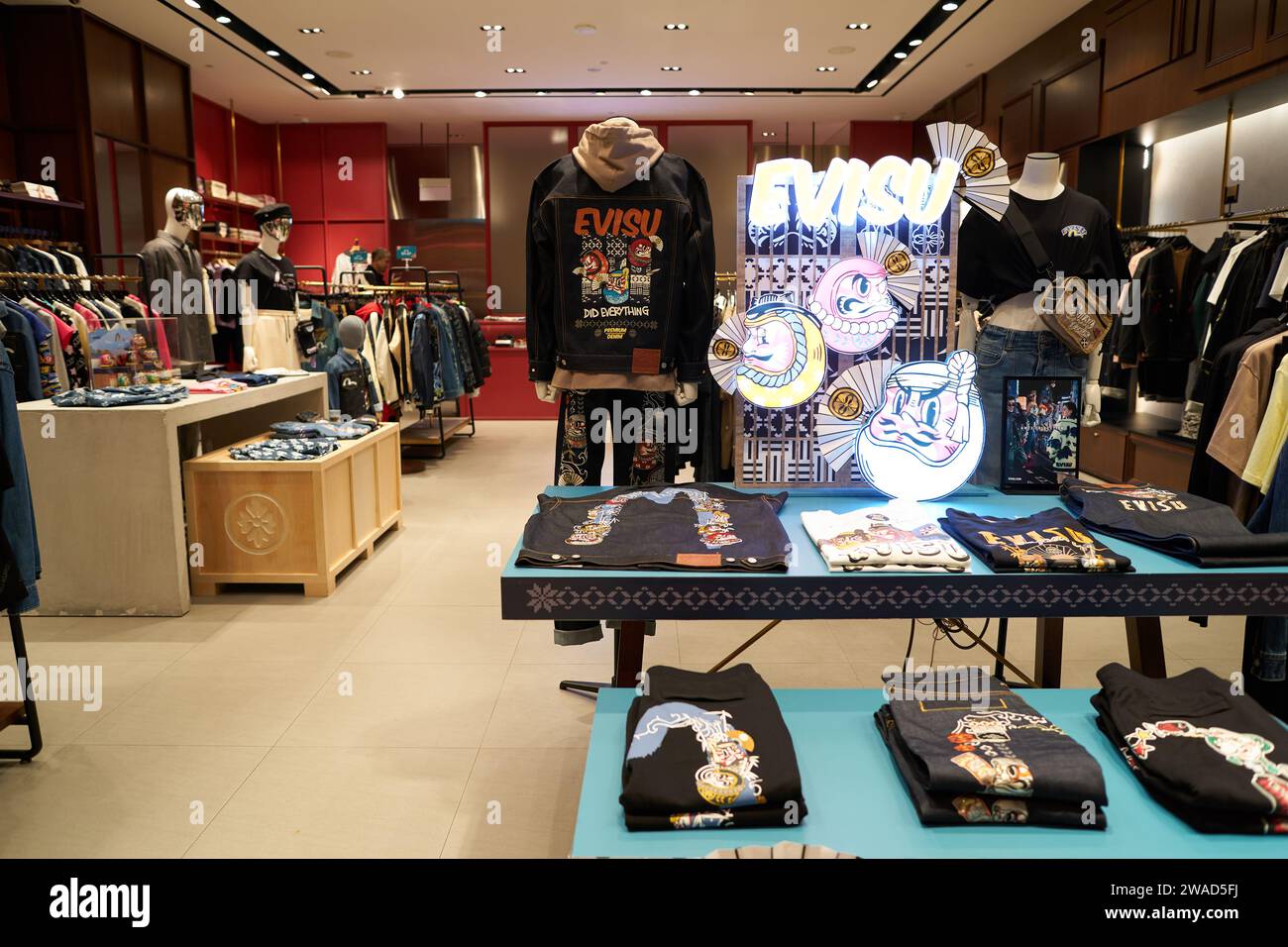 SINGAPORE - NOVEMBER 05, 2023: various clothes displayed inside Evisu ...
