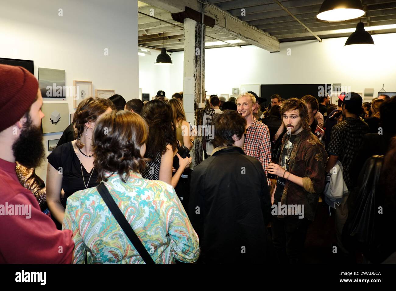 A room in an old warehouse full of people at an art opening event, Old ...