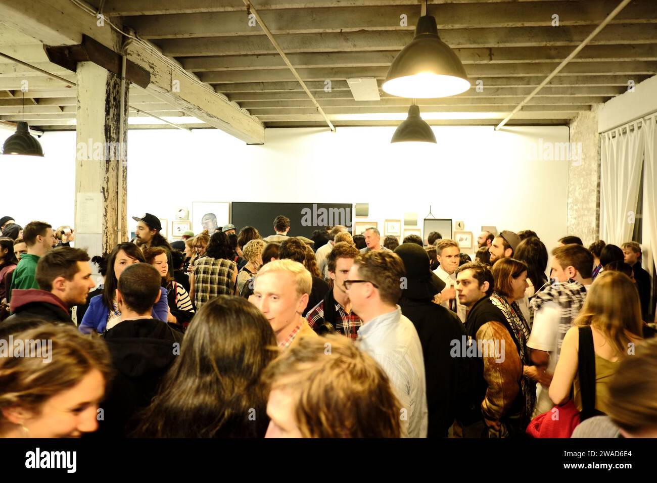 A room in an old warehouse full of people at an art opening event, Old ...