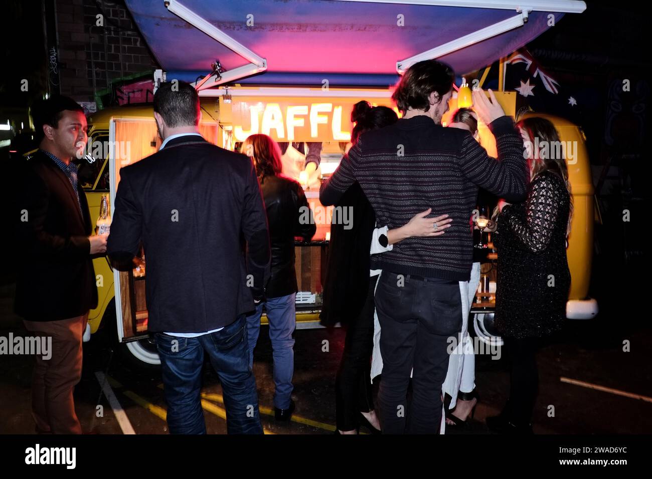 People queue for toasted sandwiches from a VW Combie food truck at ...