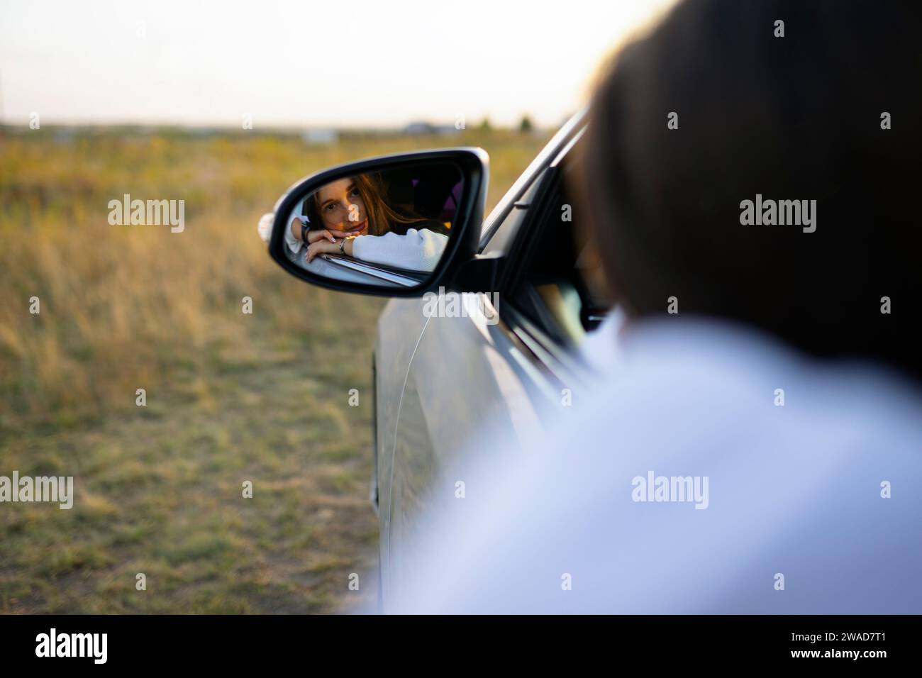 Reflection of young woman in car side view mirror Stock Photo - Alamy