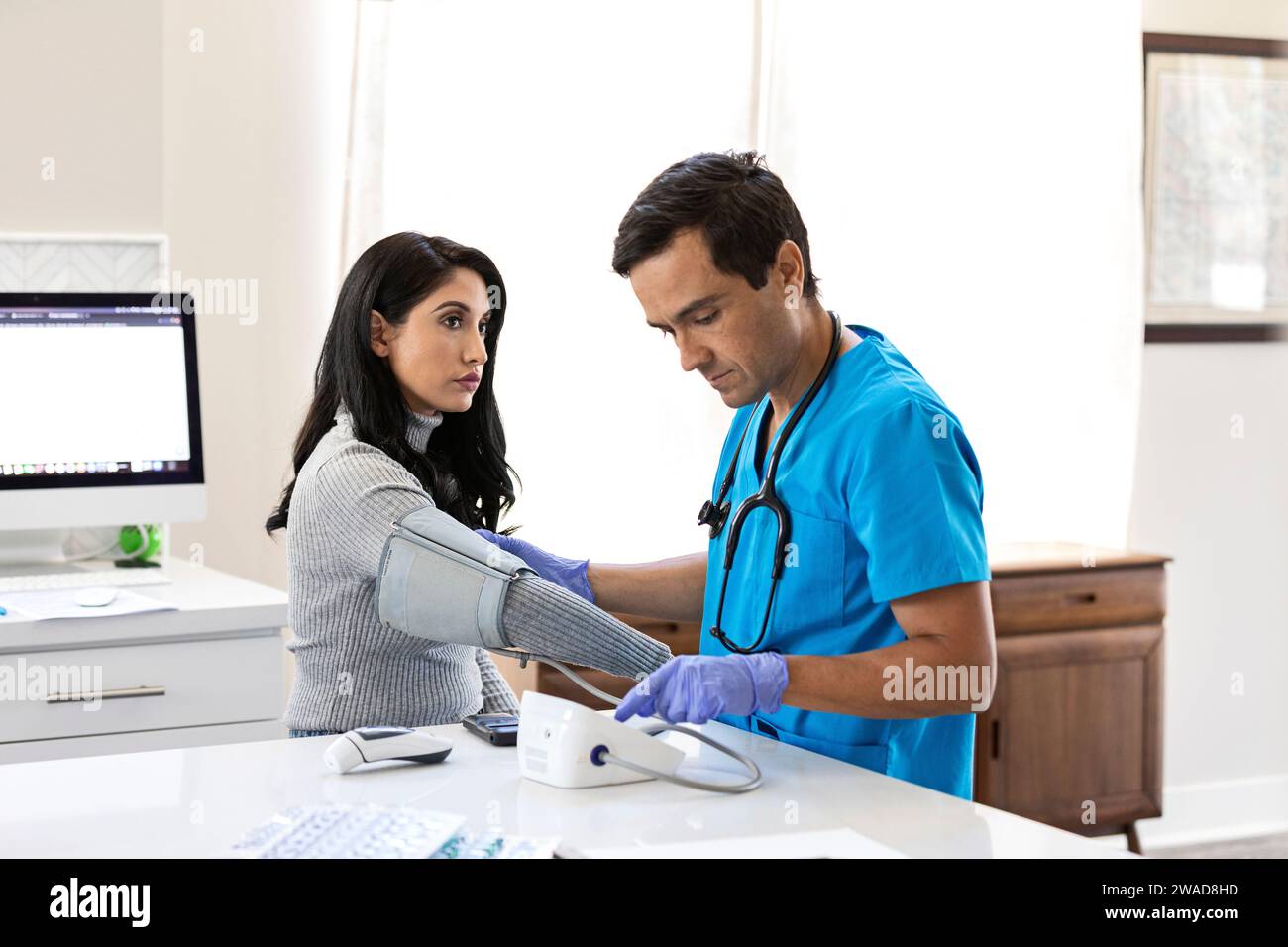 Nurse measuring blood pressure to female patient Stock Photo - Alamy
