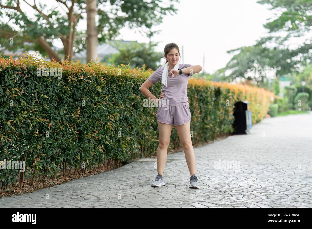 Sport young woman looking at smartwatch on her wrist, tracking fitness ...
