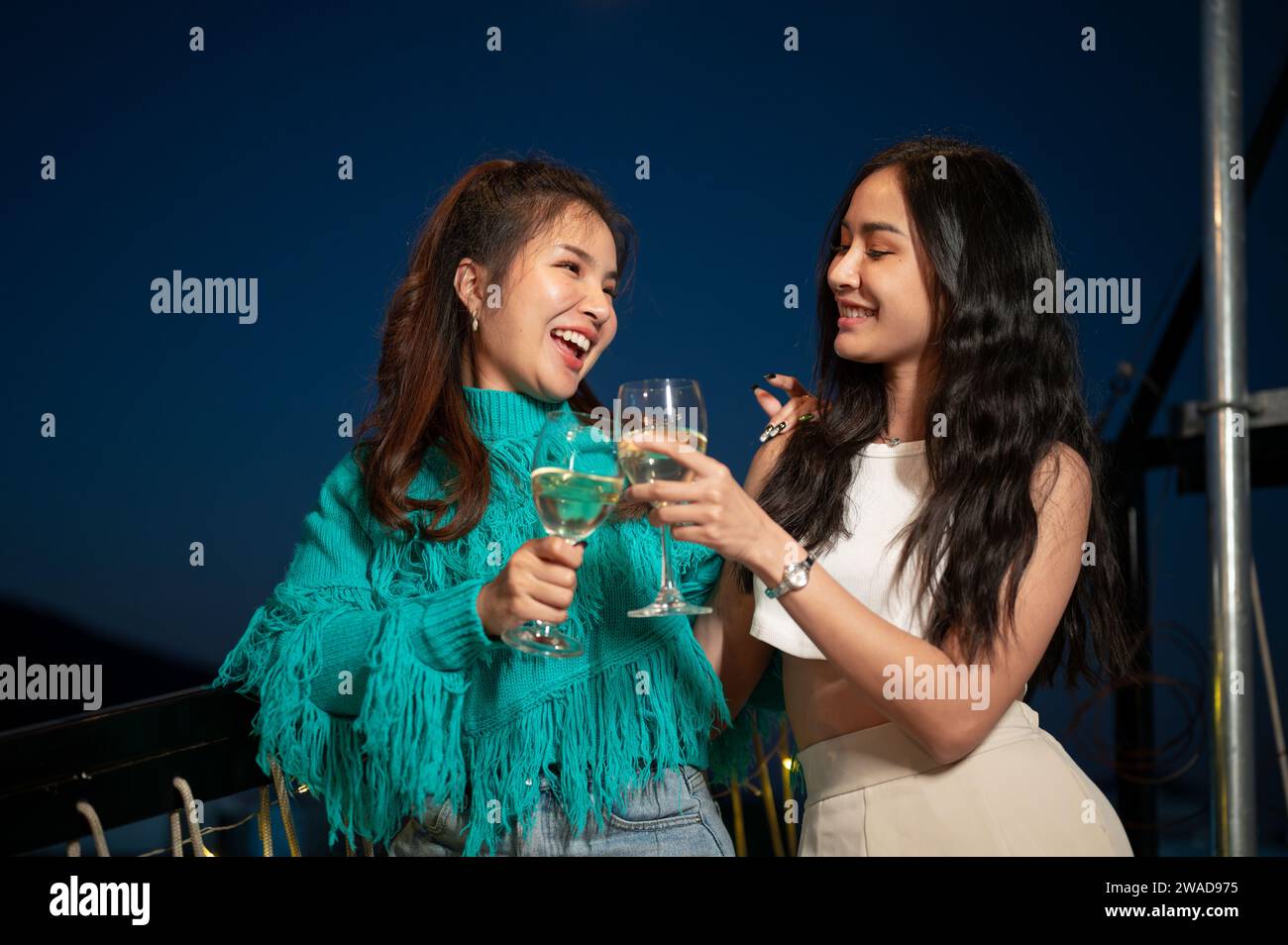 Two attractive, fun Asian female friends are enjoying dancing and ...