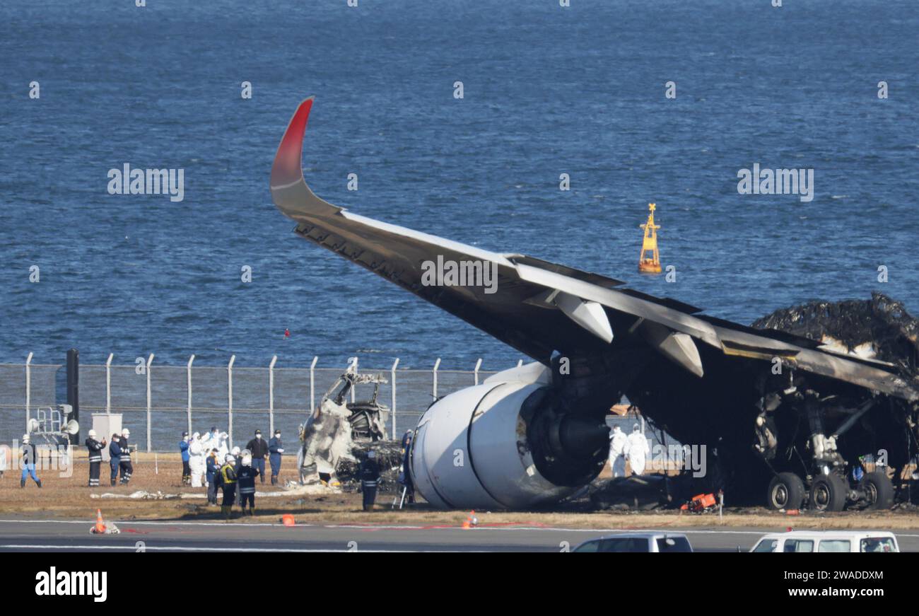 Police officers and others investigate a burnt Japan Airlines Flight ...