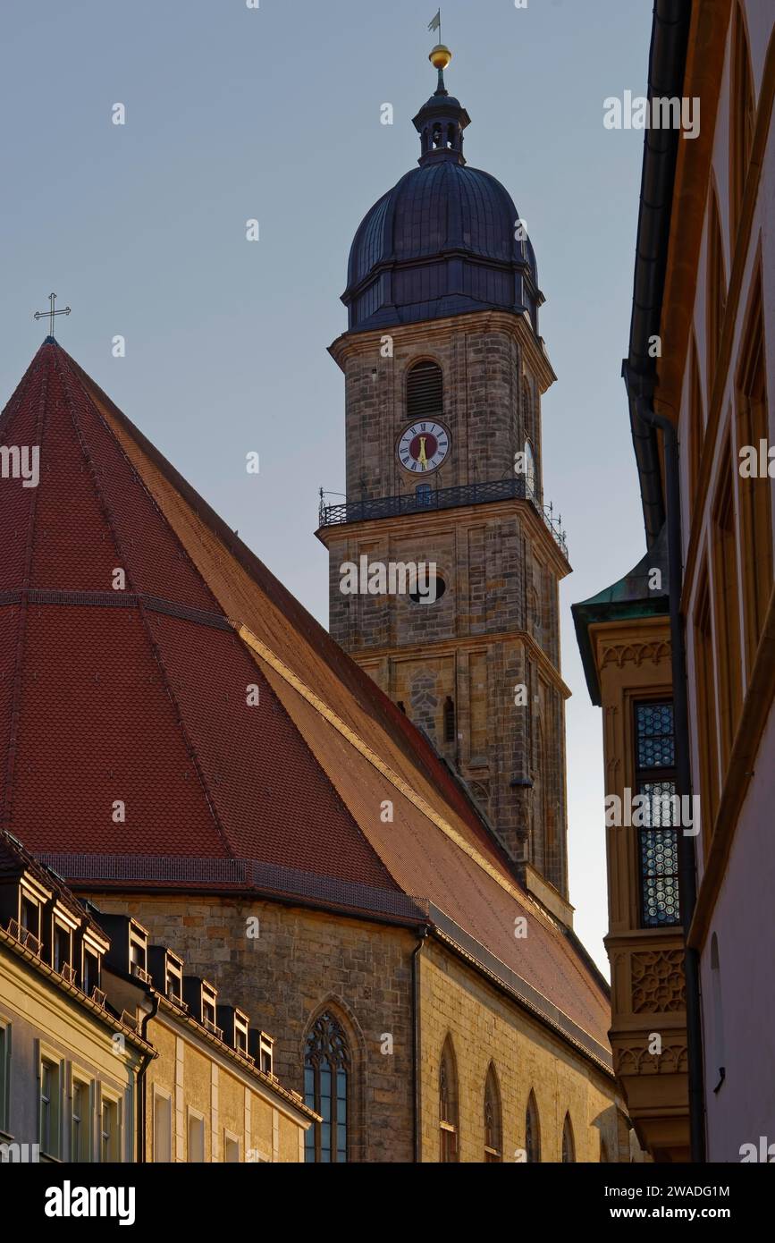 The setting sun colours the sky above an old town church Basilica of St ...