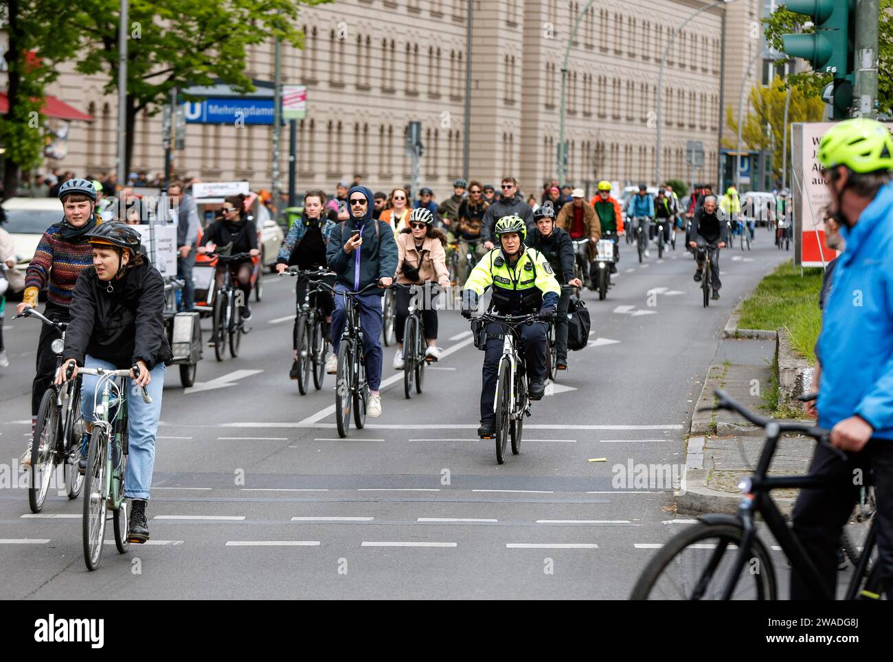 A policewoman from the Berlin bicycle squadron accompanies the bike parade demonstration, Berlin ...