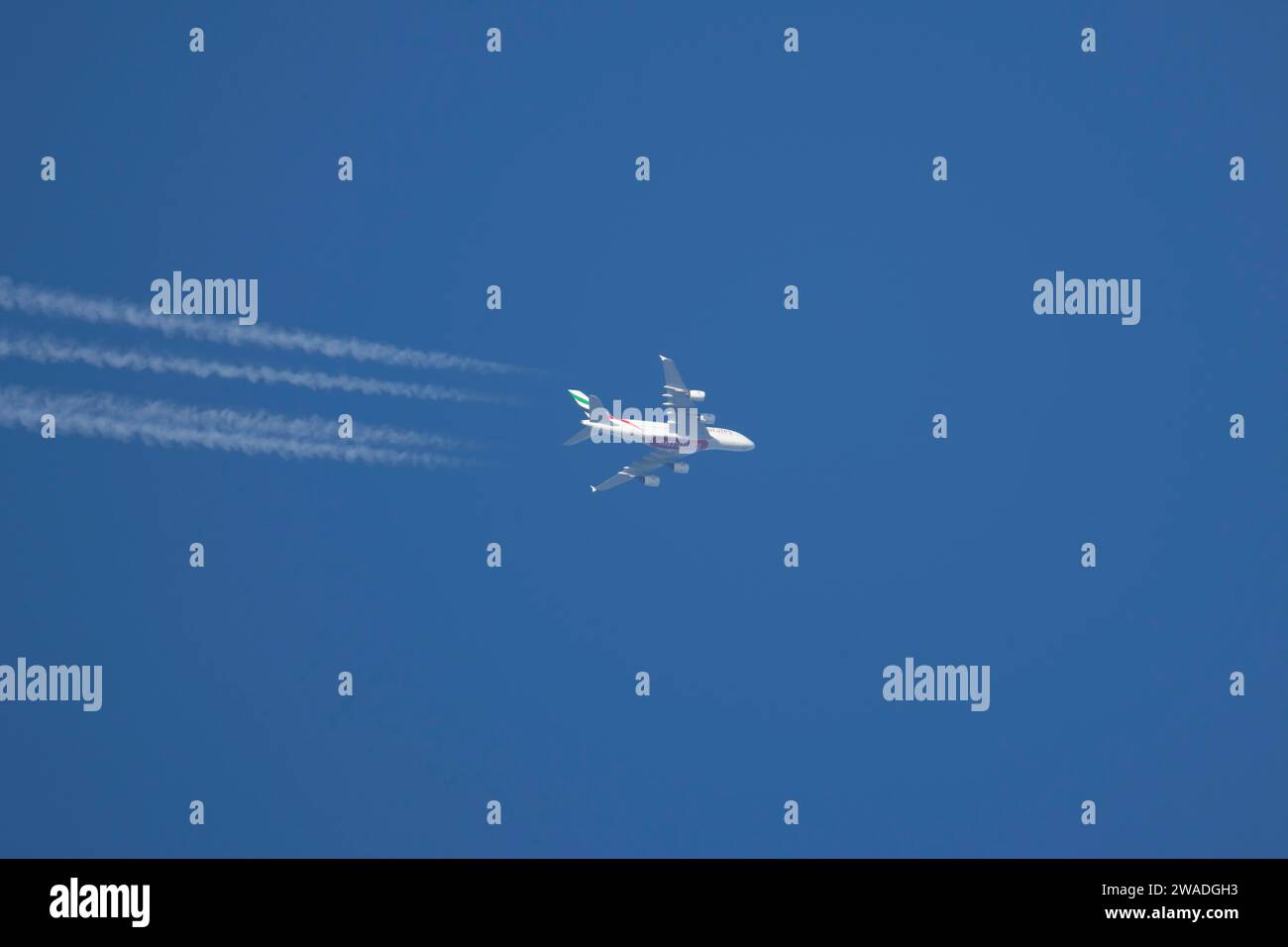 Airbus A380 aircraft of Emirates airlines flying across a blue sky ...
