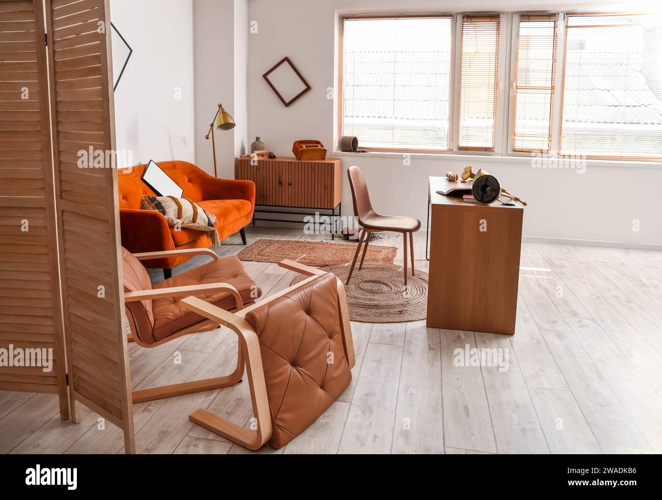 Modern workplace and sofa in messy office Stock Photo - Alamy