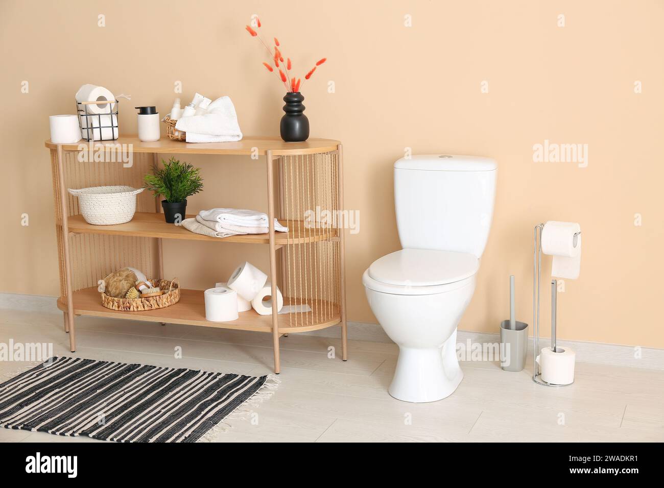 Ceramic toilet bowl and different bath supplies in interior of modern ...