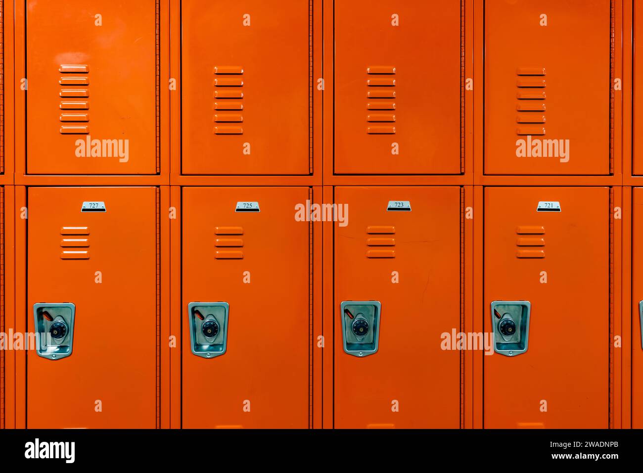 Orange metal lockers along a nondescript hallway in a typical US High ...