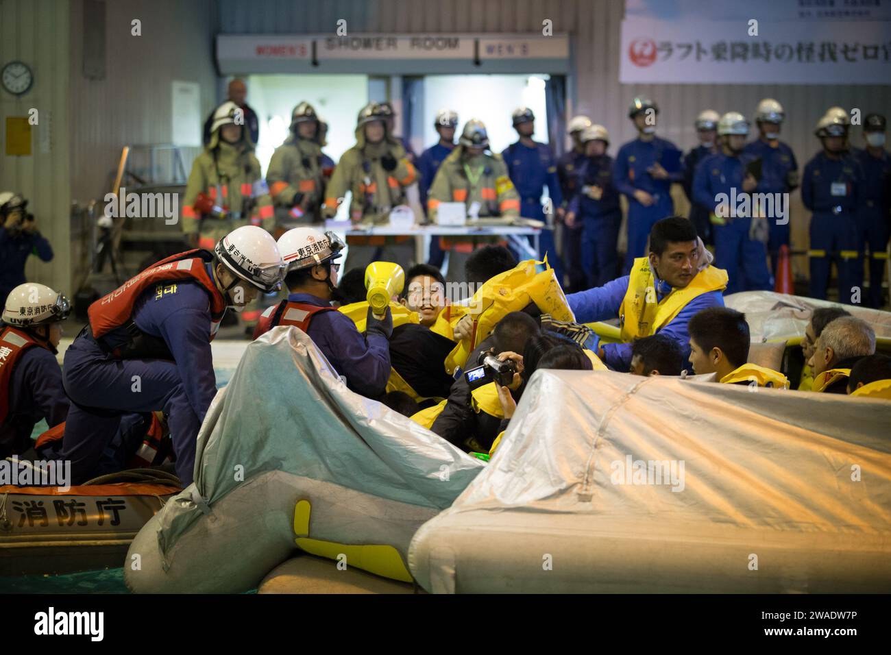 JAL flight attendants conduct a joint emergency evacuation drill with ...