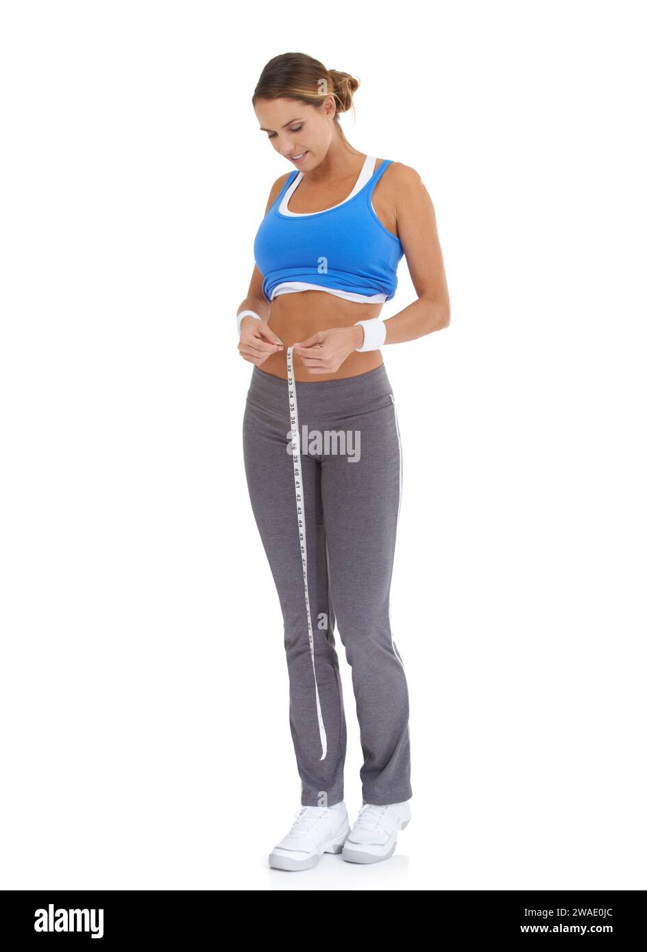 Woman, stomach and measure tape in studio for diet, weight loss and ...