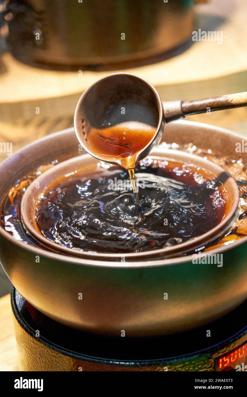 Traditional Chinese copper pot is cooking Pu'er tea, making tea around ...