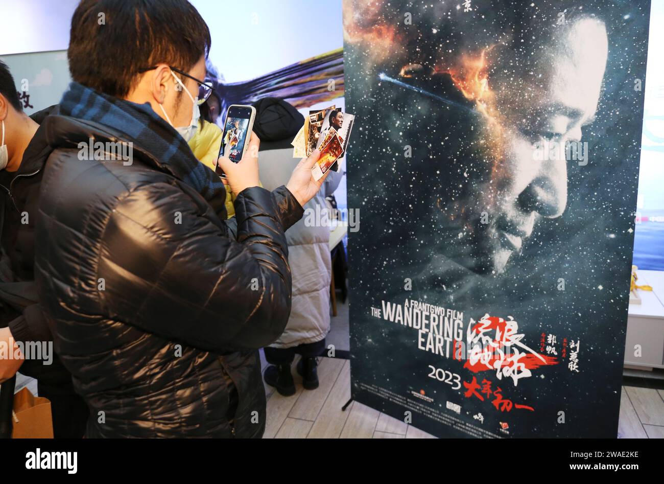 SHANGHAI, CHINA - JANUARY 22, 2023 - Fans photograph a poster of actor Wu Jing of The Wandering ...