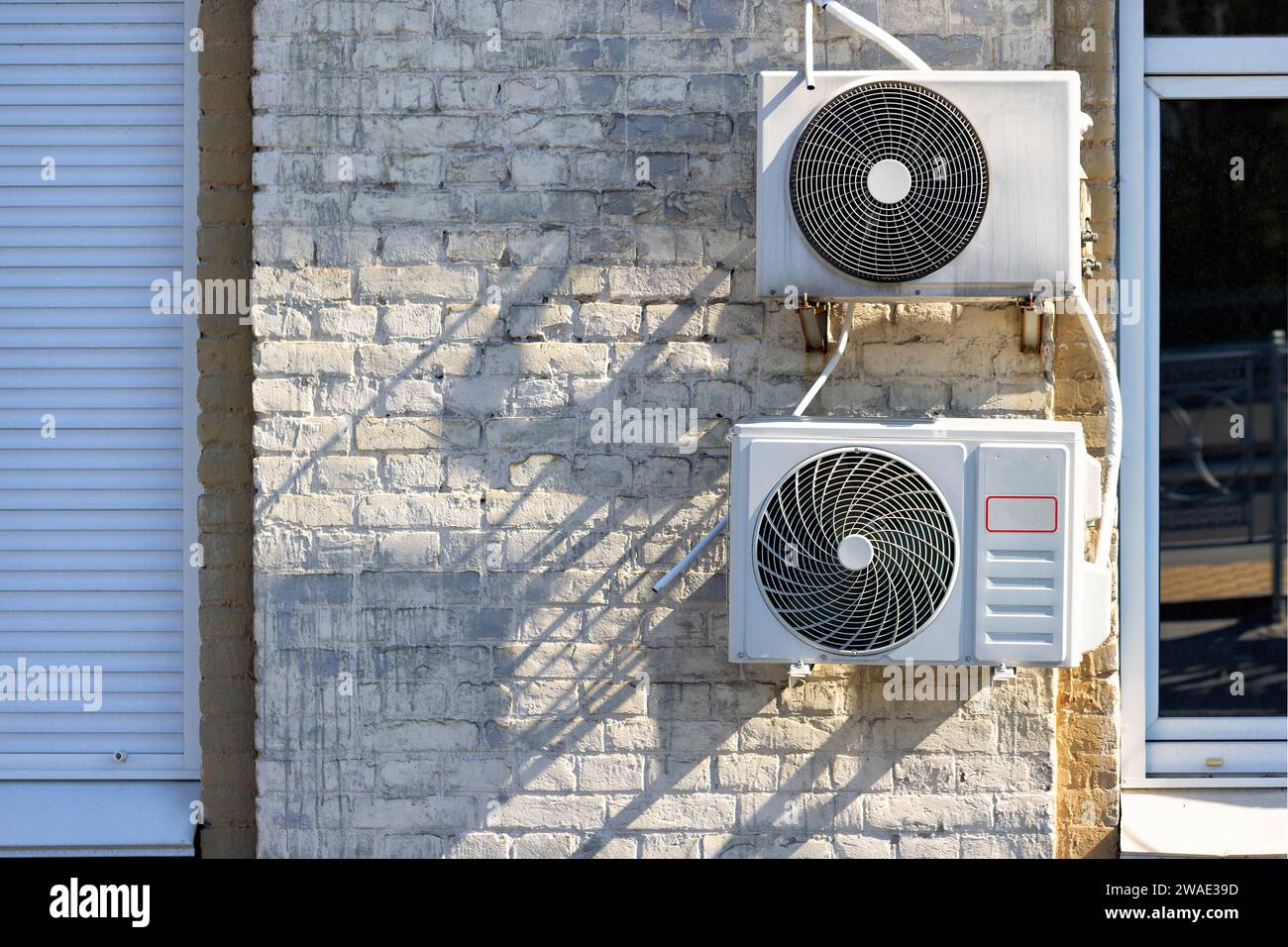 External air conditioner units on an old brick wall with a fragment of ...