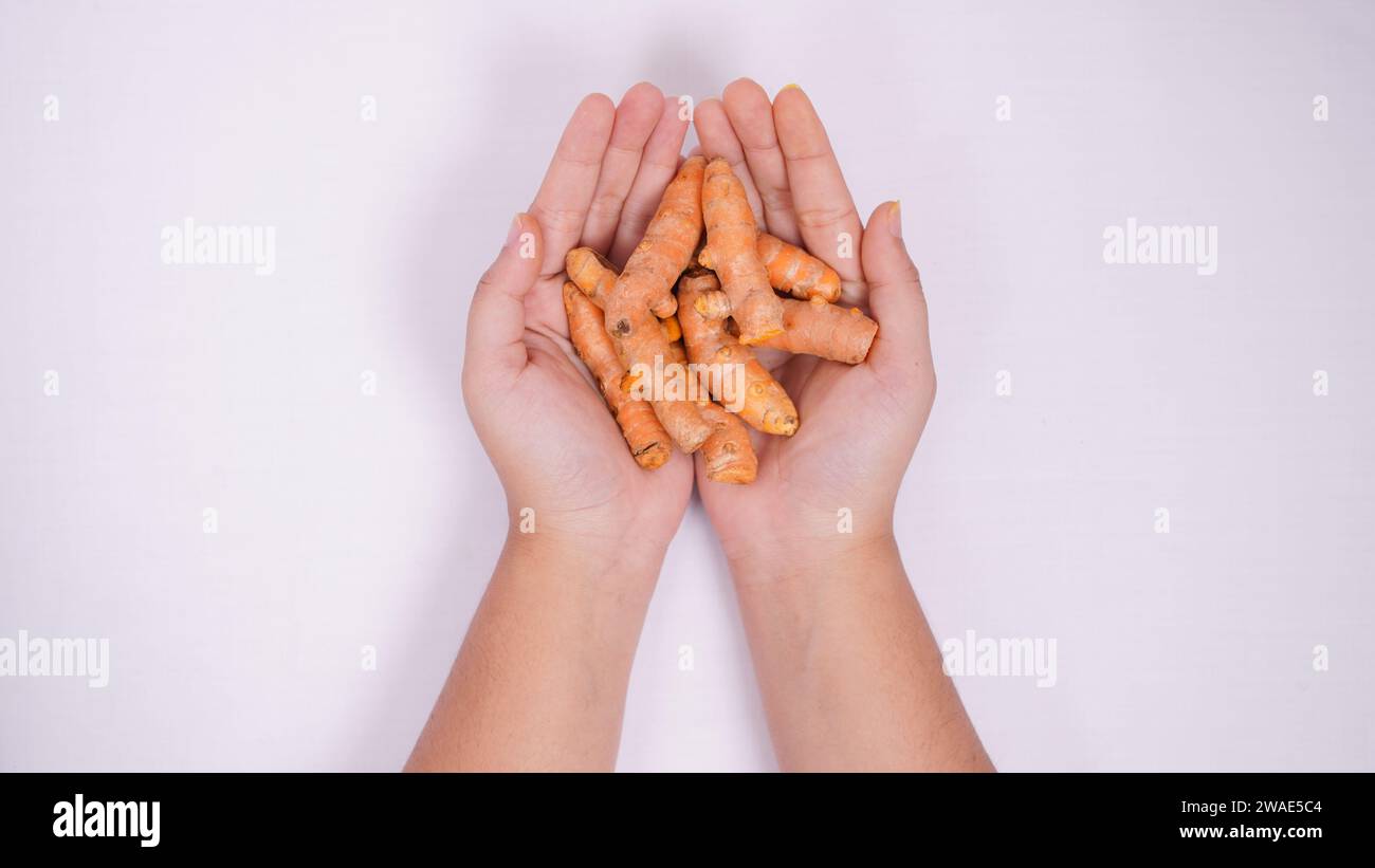 A top view of turmeric in the palms of a hand isolated on a white ...