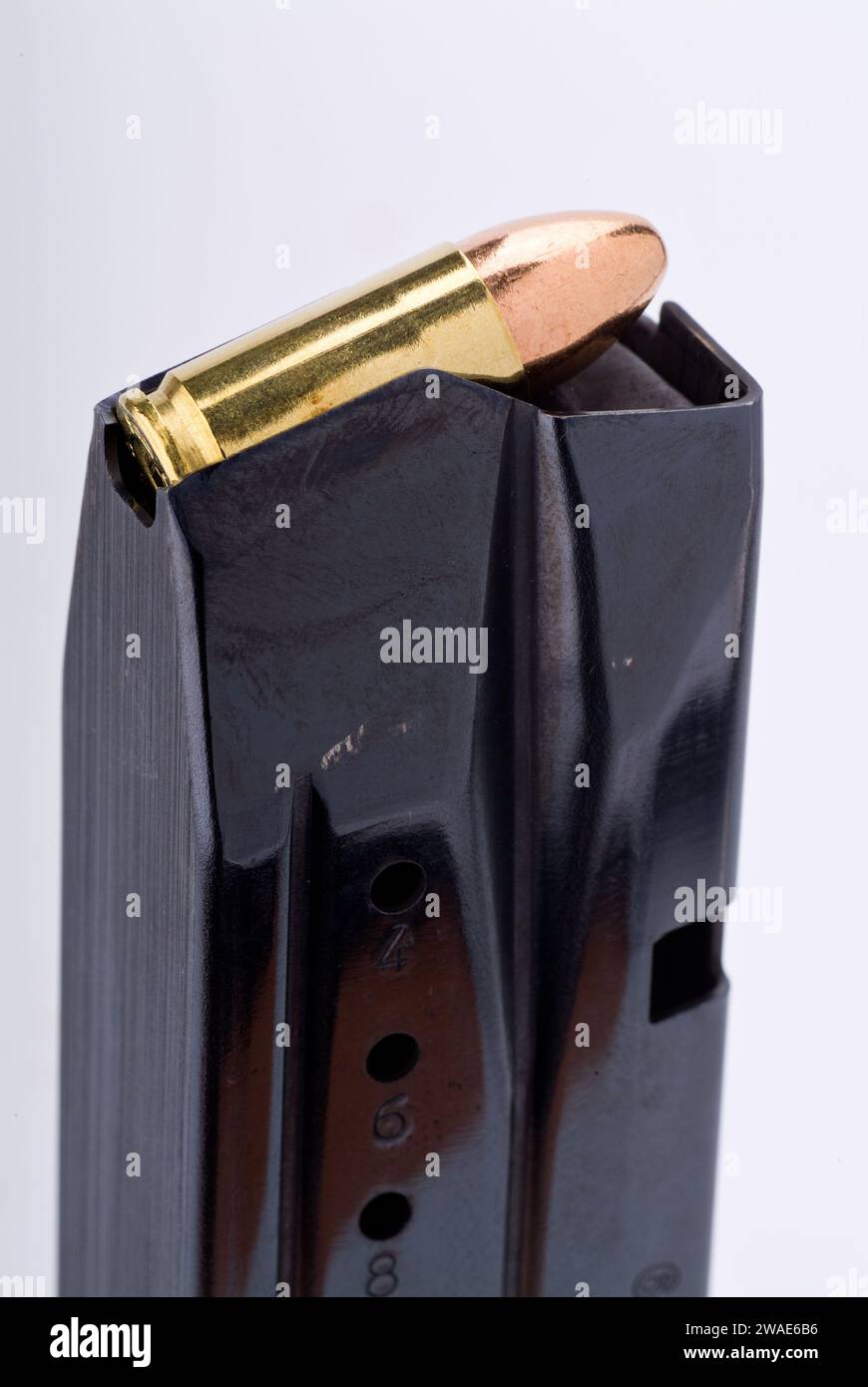 A vertical shot of a loaded 9 mm pistol magazine isolated on the white ...
