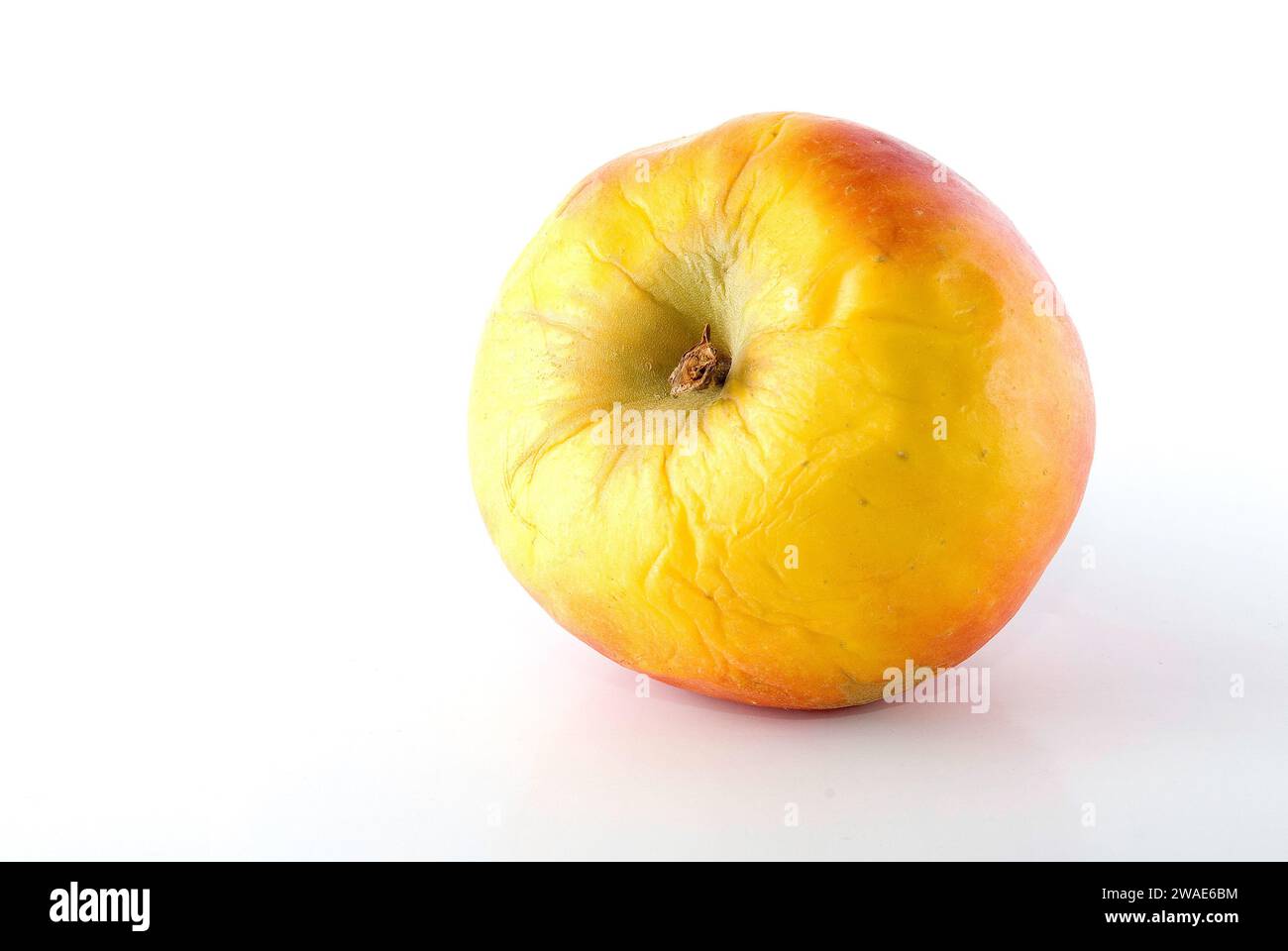 A wrinkled apple isolated on white background Stock Photo - Alamy