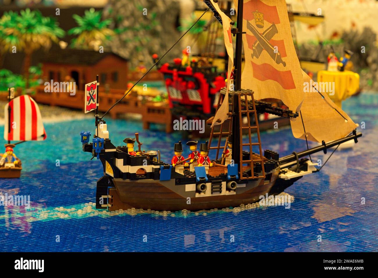 A closeup shot of a LEGO model of a pirate ship at the dock at ...