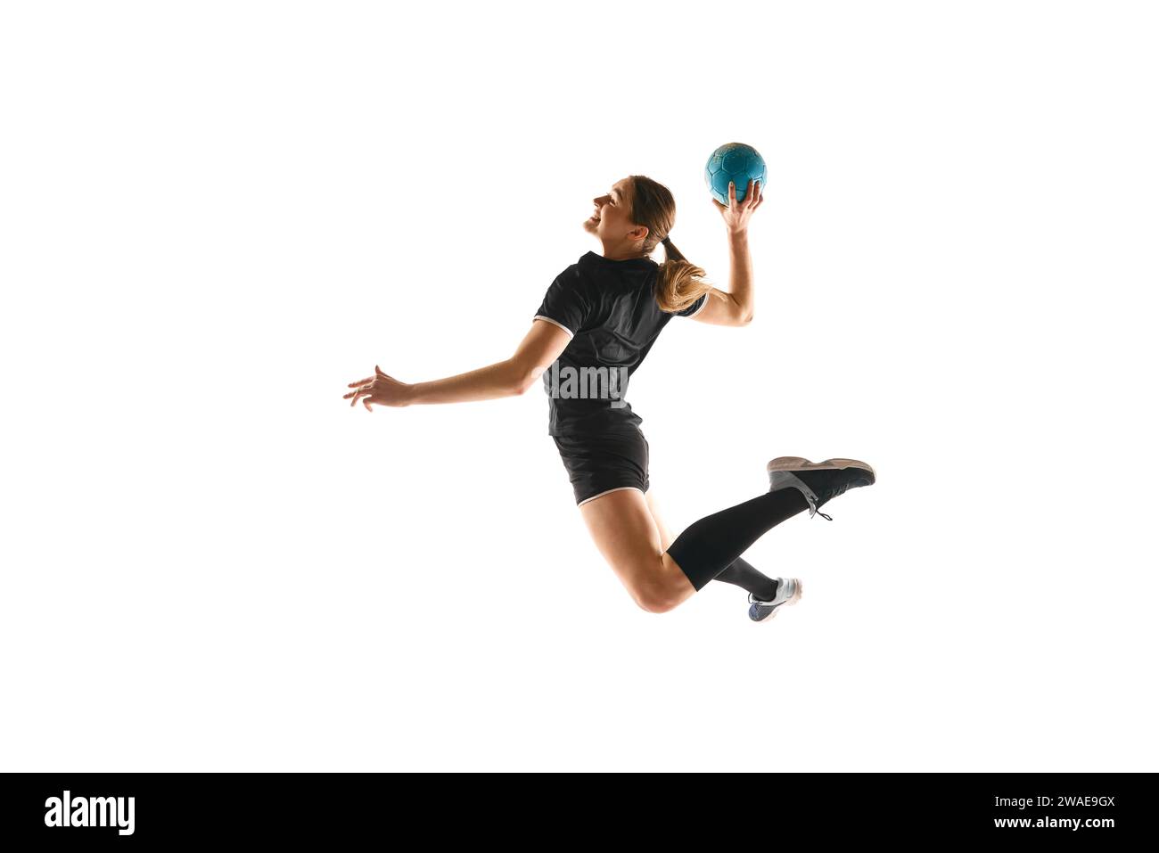 Determined female athlete practicing handball moves with concentration ...