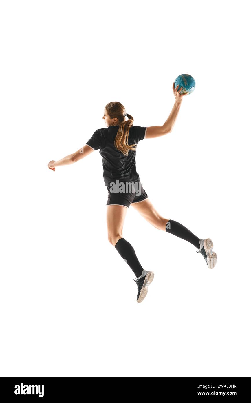 Dynamic portrait of focused female handball athlete in mid-throw ...