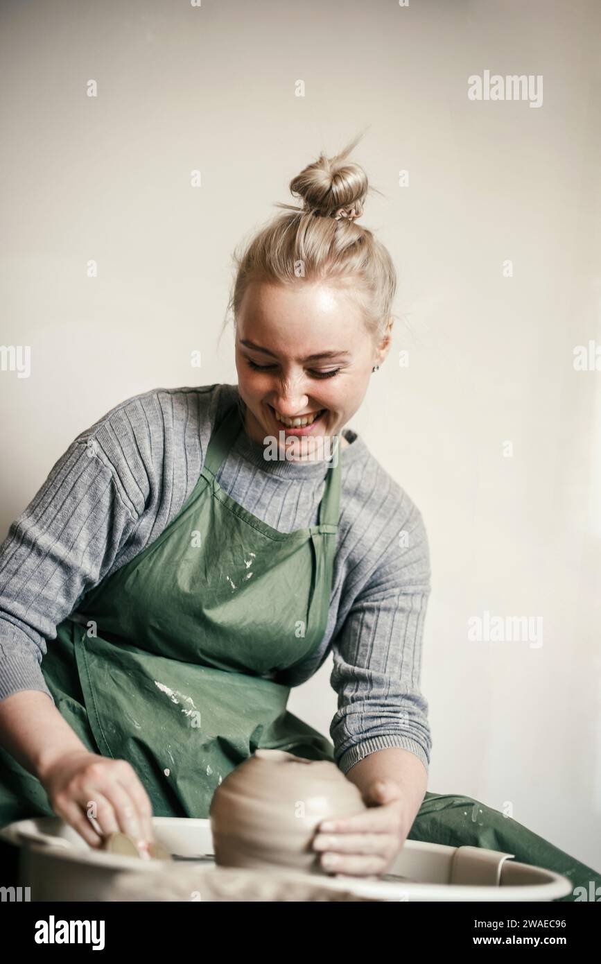 Young woman moulding pottery on potters wheel Stock Photo - Alamy
