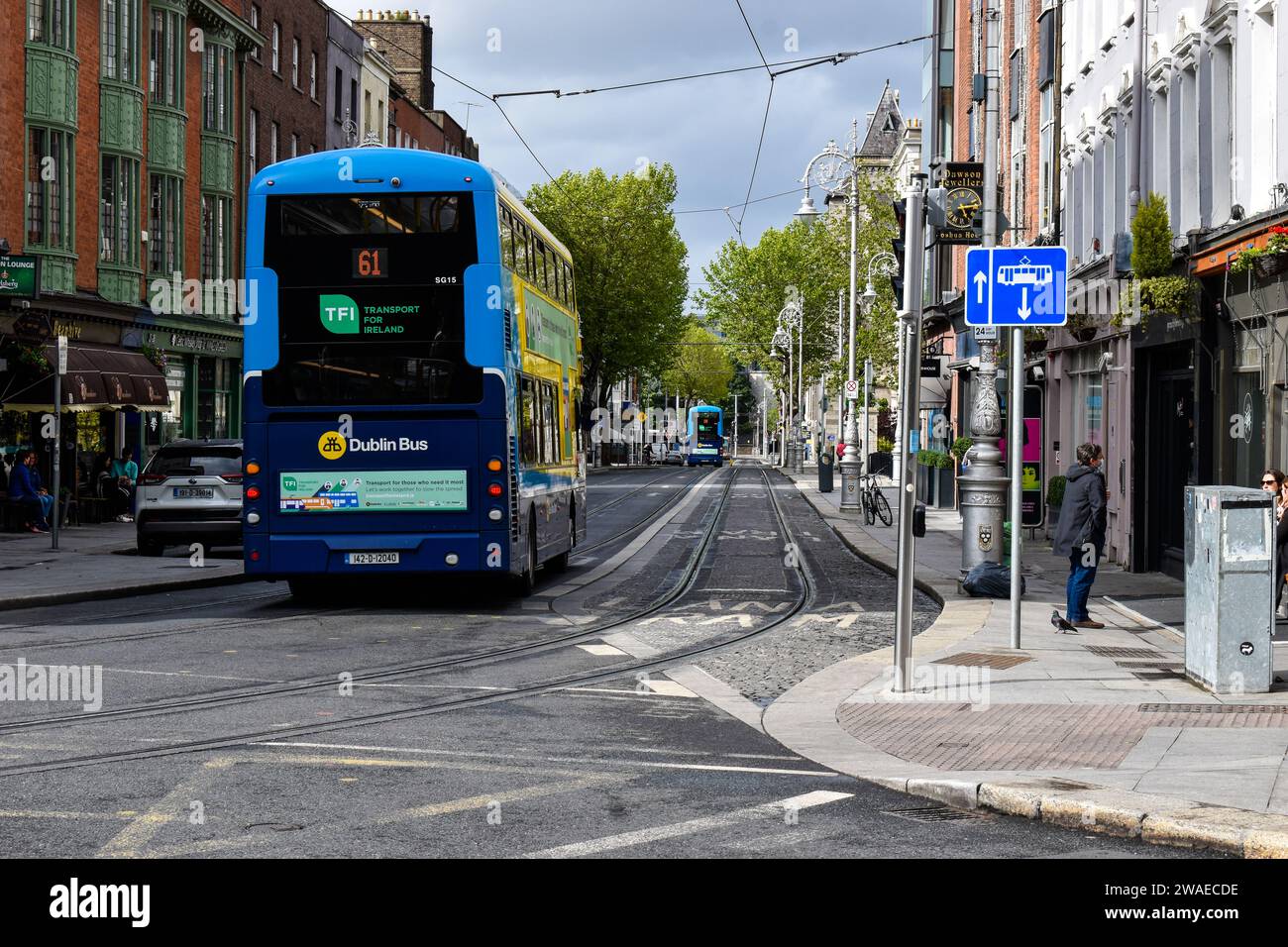 A blue double-decker bus driving on a busy street alongside other ...