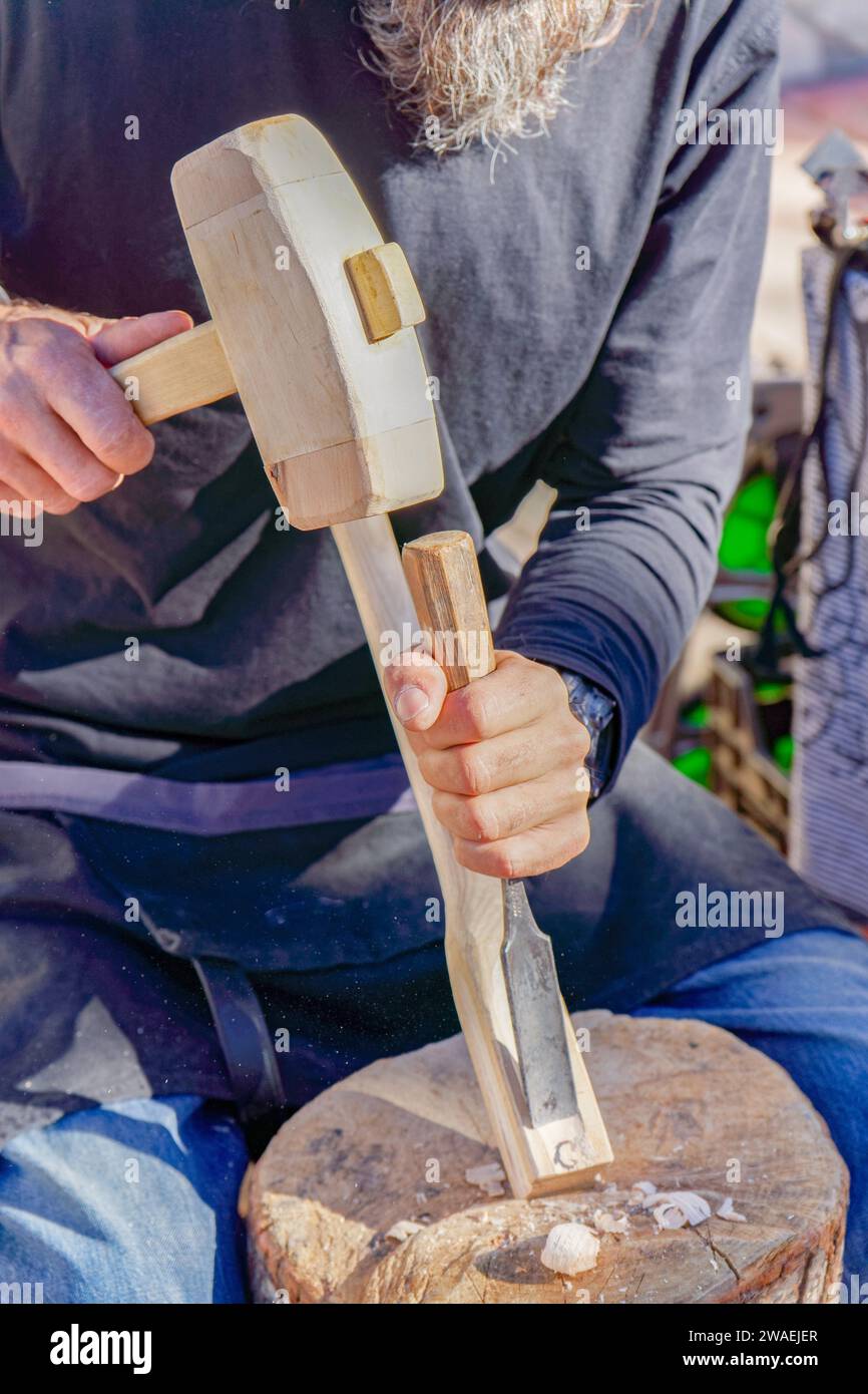 craftsman working with wood at a street market at his stall of handmade ...