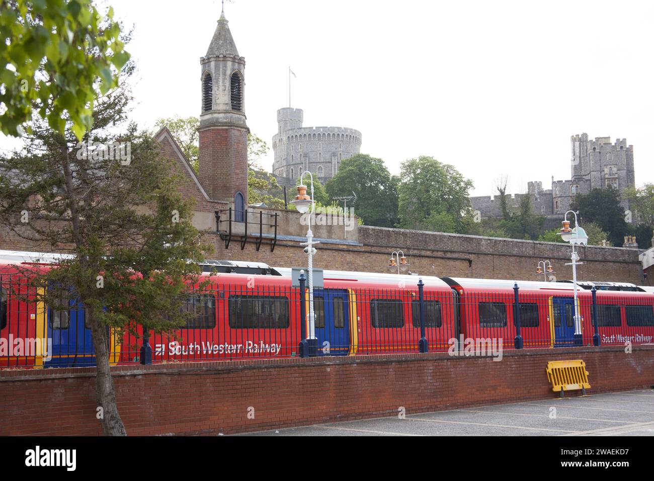 A train pulls up at the station in Windsor with Windsor Castle behind ...