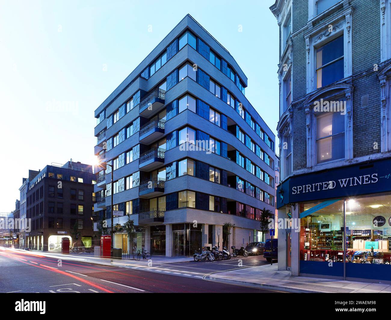 Corner elevation of building at dusk. Westbourne House, London, United ...