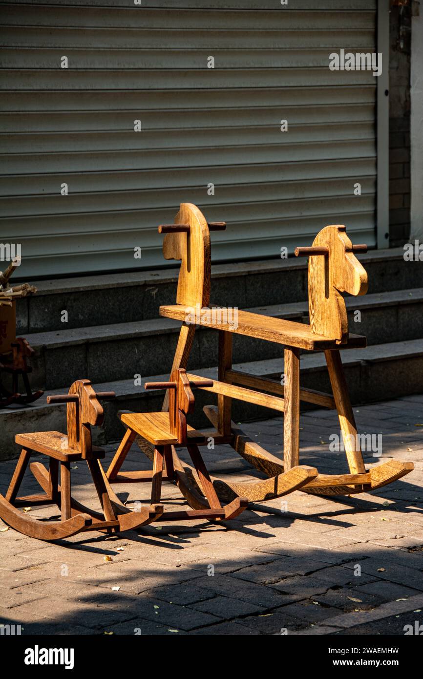 A scene of two antique rocking horses situated on a paved sidewalk ...