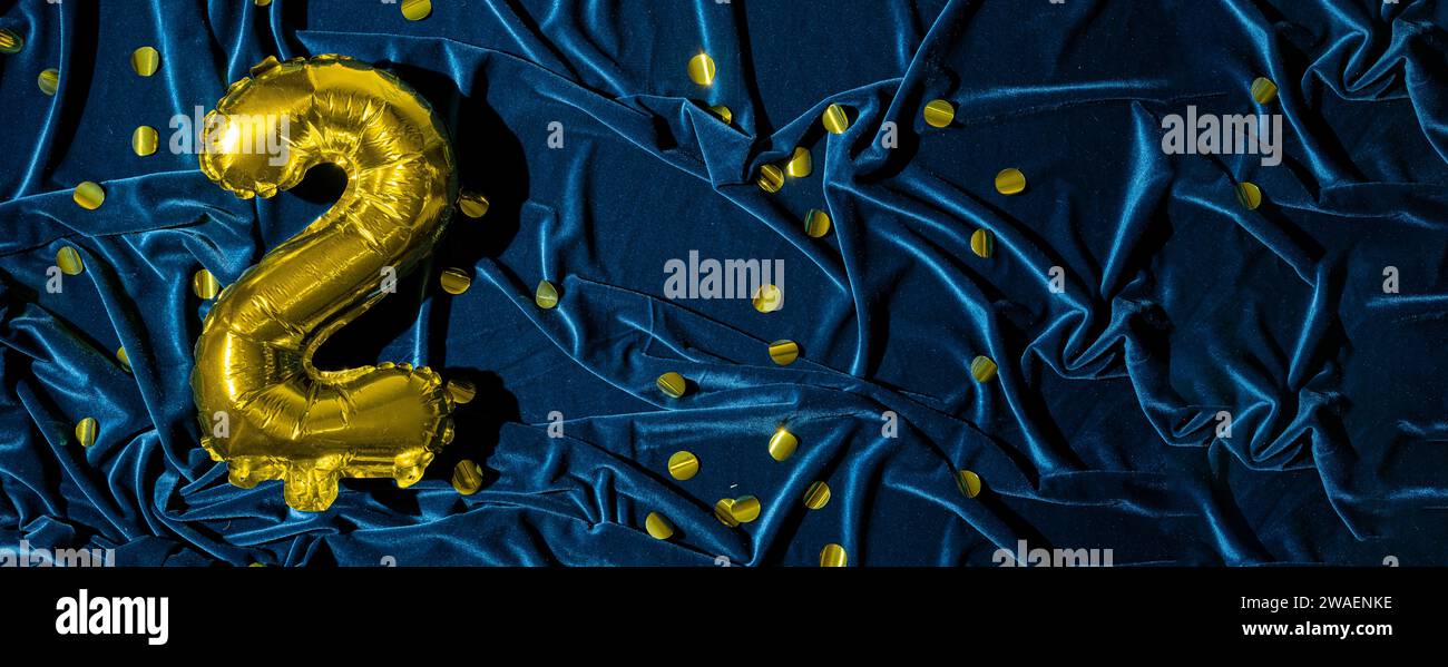 Gold foil balloon number two on blue velvet. Birthday greeting card with inscription 2. Golden ...