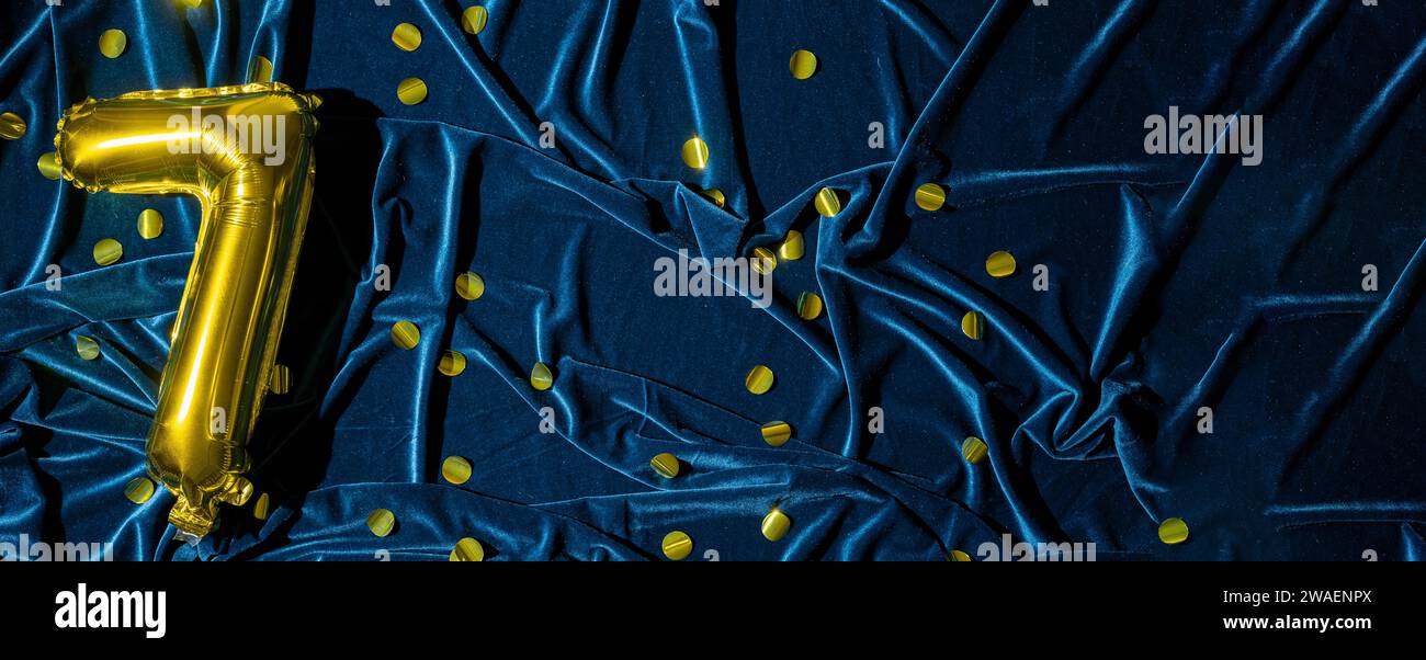 Gold foil balloon number seven on blue velvet. Birthday greeting card with inscription 7. Golden ...