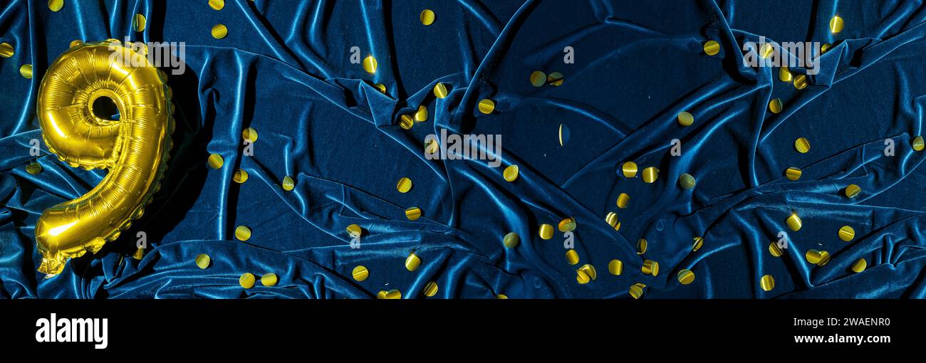 Gold foil balloon number nine on blue velvet. Birthday greeting card with inscription 9. Golden ...