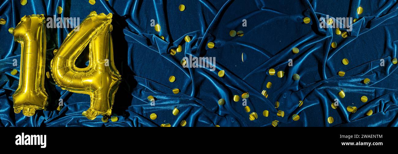 number fourteen, gold foil balloon number on a blue velvet background ...