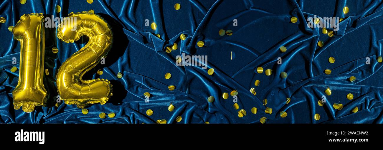 number twelve, gold foil balloon number on a blue velvet background ...