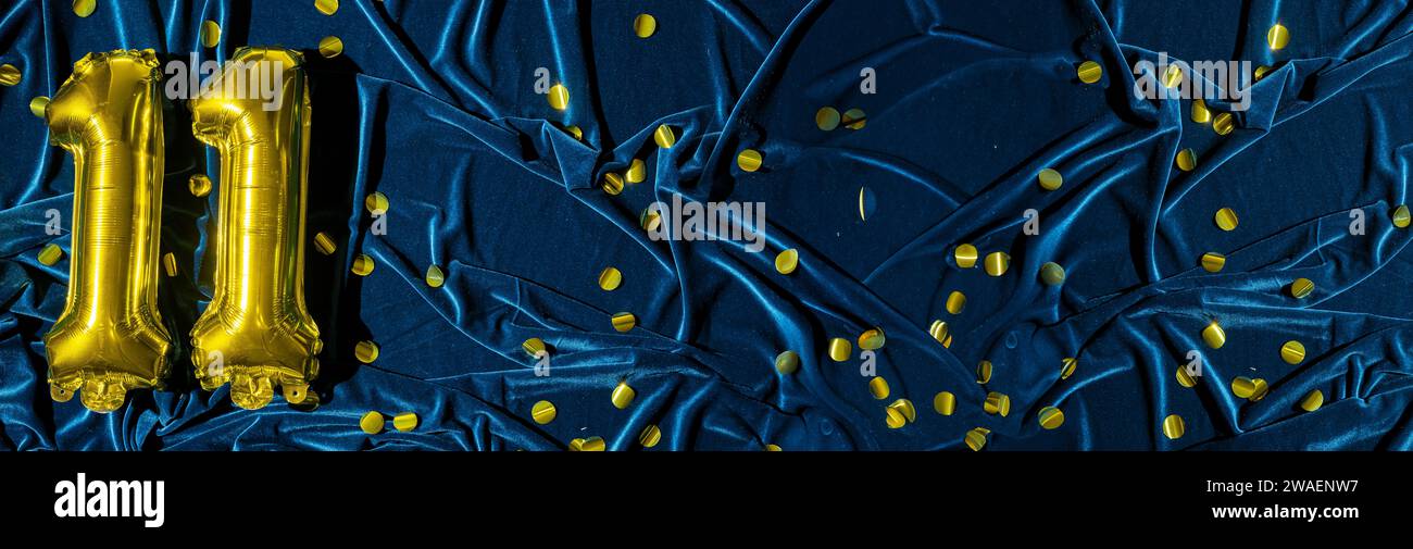 number 11, gold foil balloon number on a blue velvet background with ...