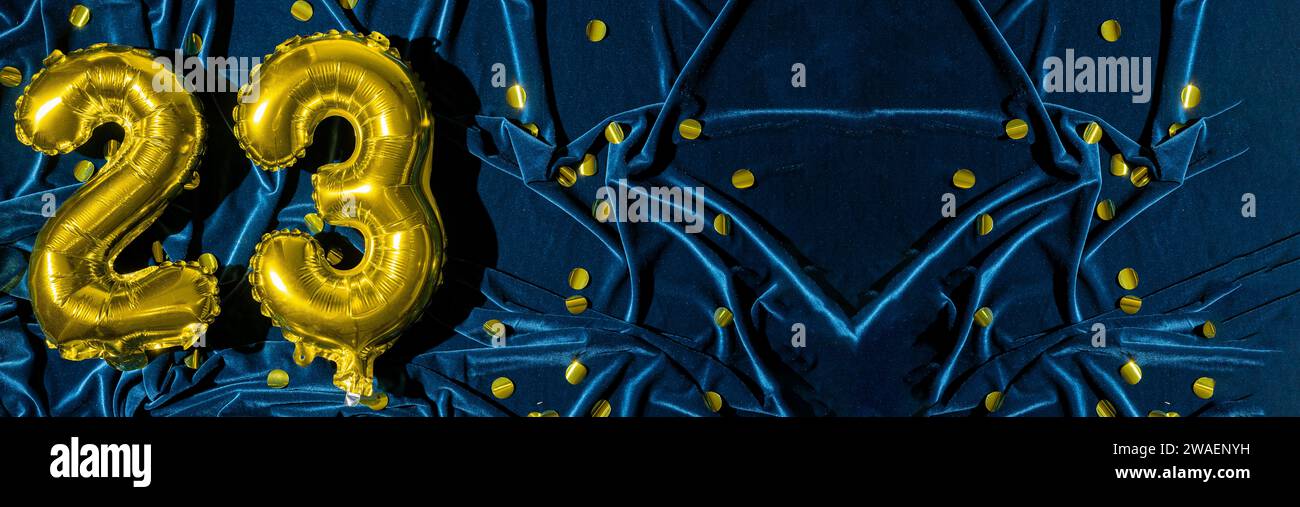number twenty three, gold foil balloon number on blue velvet background ...