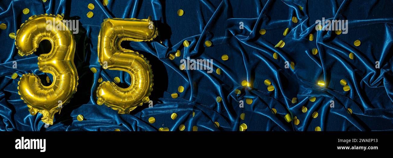 number thirty five, gold foil balloon number on blue velvet background ...