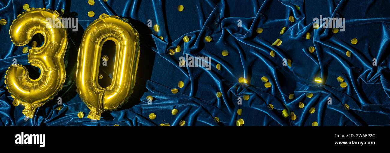 number thirty, gold foil balloon number on a blue velvet background ...