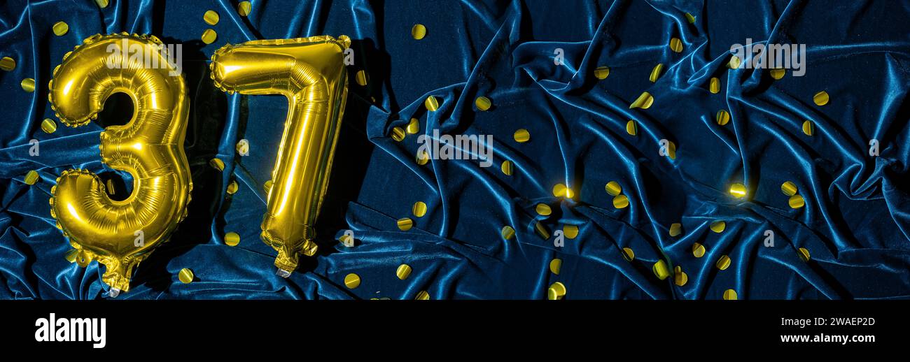 number thirty seven, gold foil balloon number on blue velvet background ...